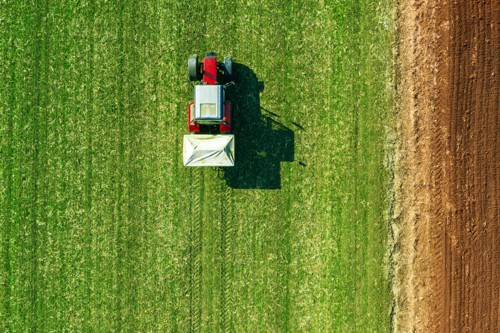 Agricultural tractor fertilizing wheat crop field with NPK ...